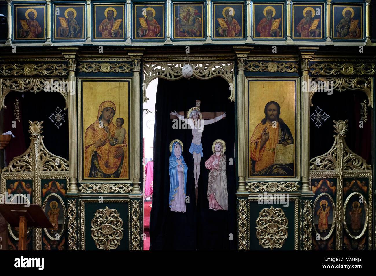 An old wooden iconostasis with icons and religious paintings separating ...