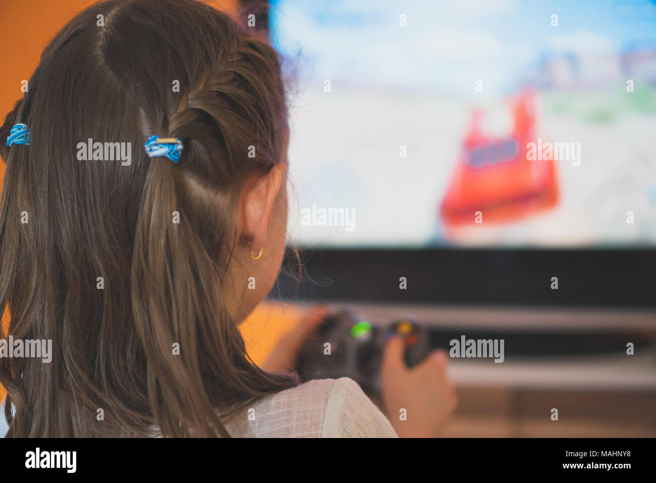Little girl playing computer game with a joystick Stock Photo - Alamy