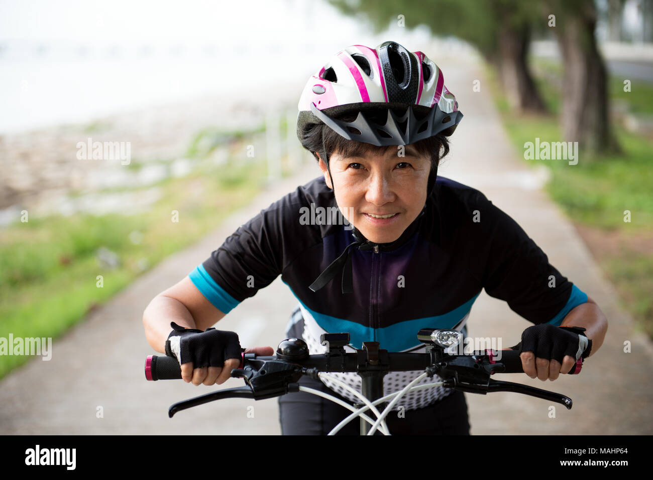 Older woman riding bike hi-res stock photography and images - Alamy