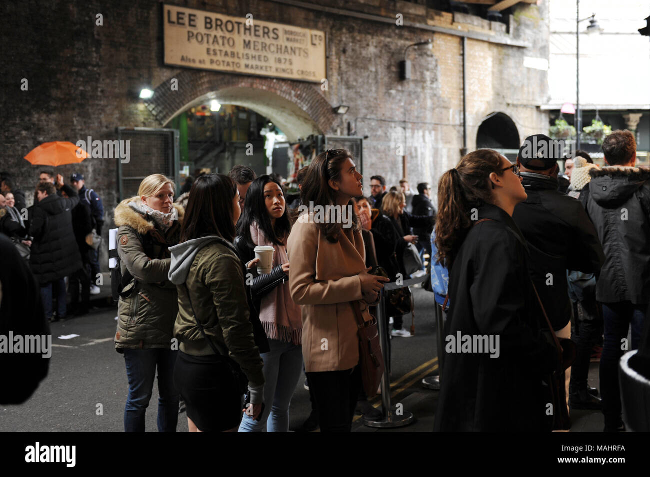 Tourists and visitors queue to order food from Fish at Borough Market ...