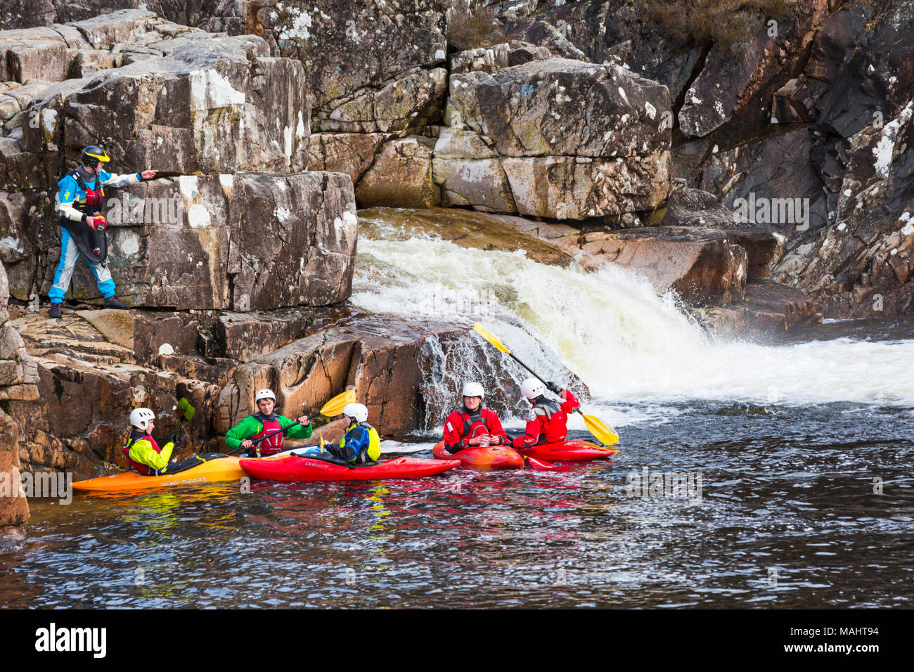 Group of teenagers training in kayaks at River Etive Falls, Glencoe ...