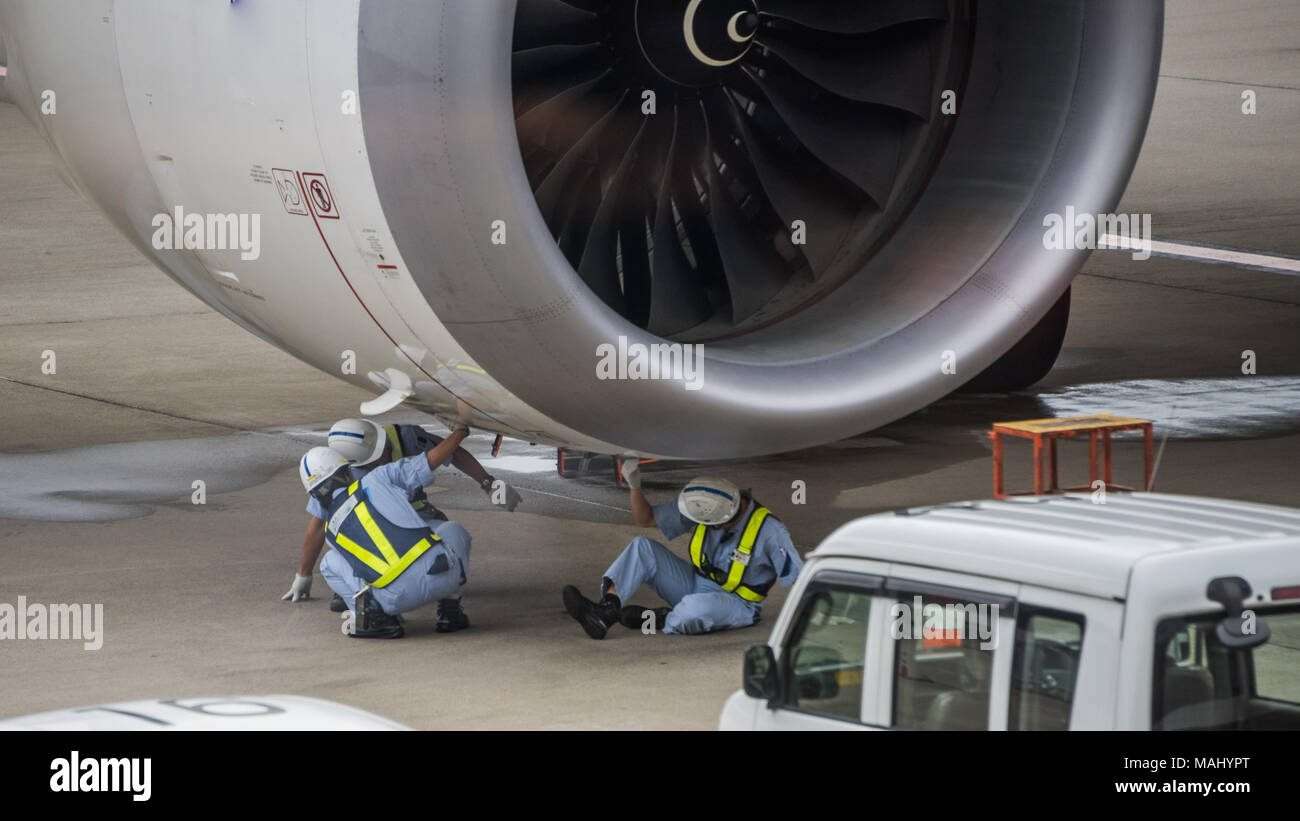 3 workers opening up doors on jet engine to perform maintenance Stock ...