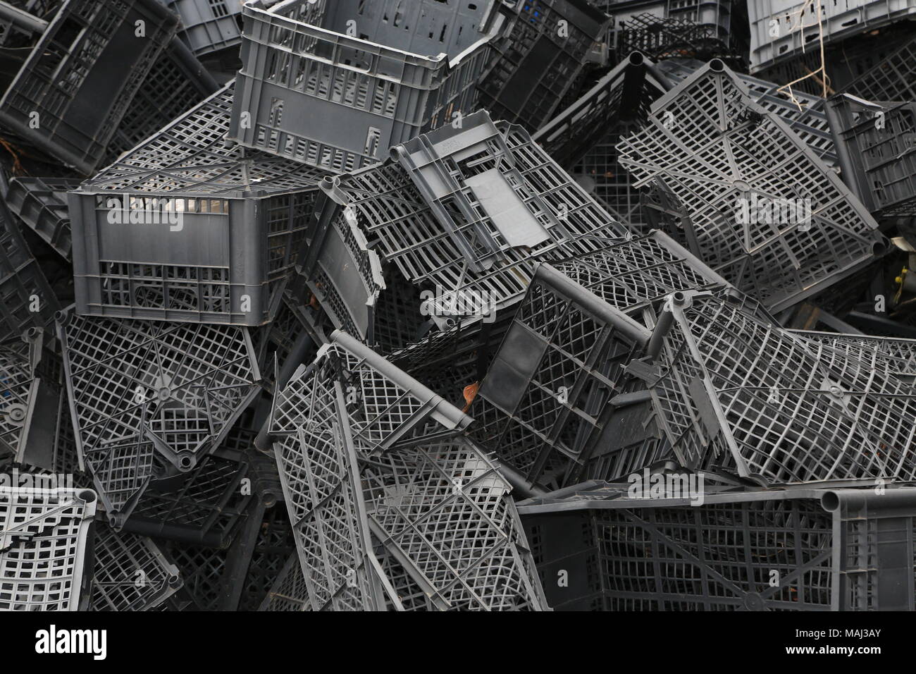 Piled black crates for scrap Stock Photo - Alamy