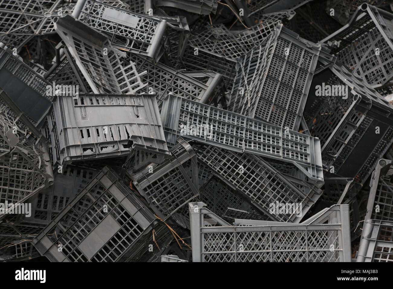 Piled black crates for scrap Stock Photo - Alamy