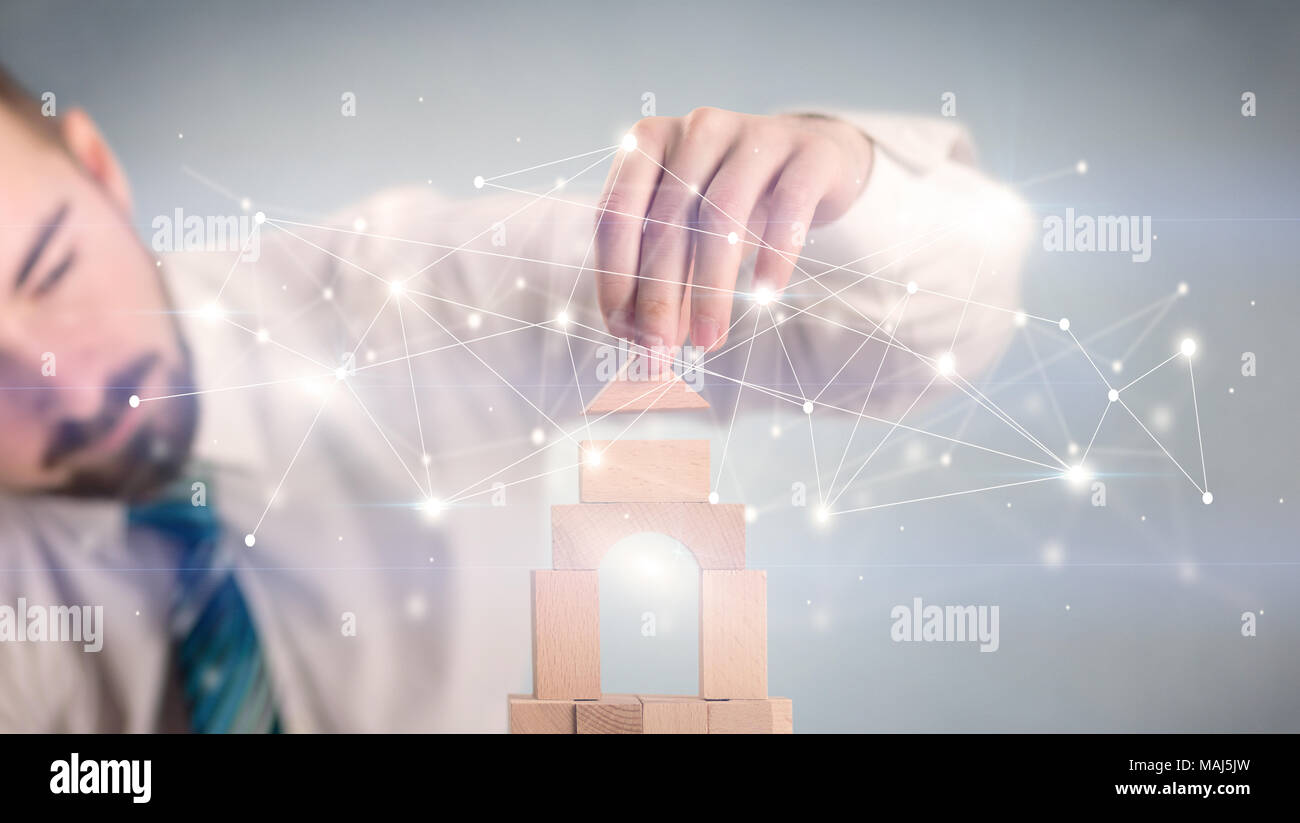 Young handsome businessman using wooden building blocks with ...