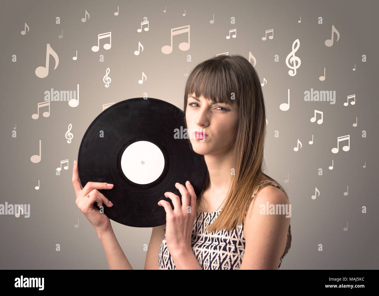 Young lady holding vinyl record on a brown background with musical ...