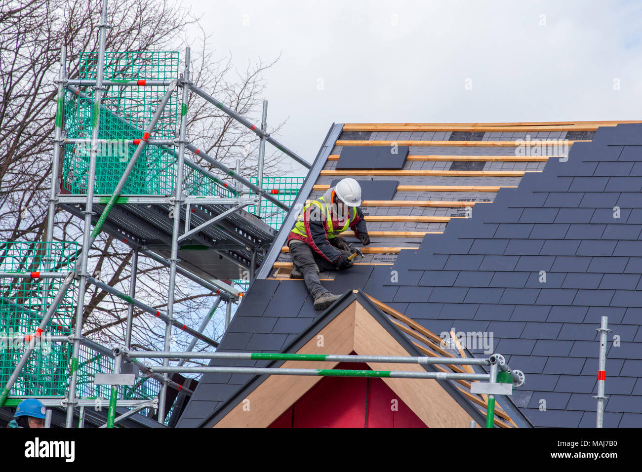 Roof tiler fitting tiles along roof edges on a new build house UK Stock ...