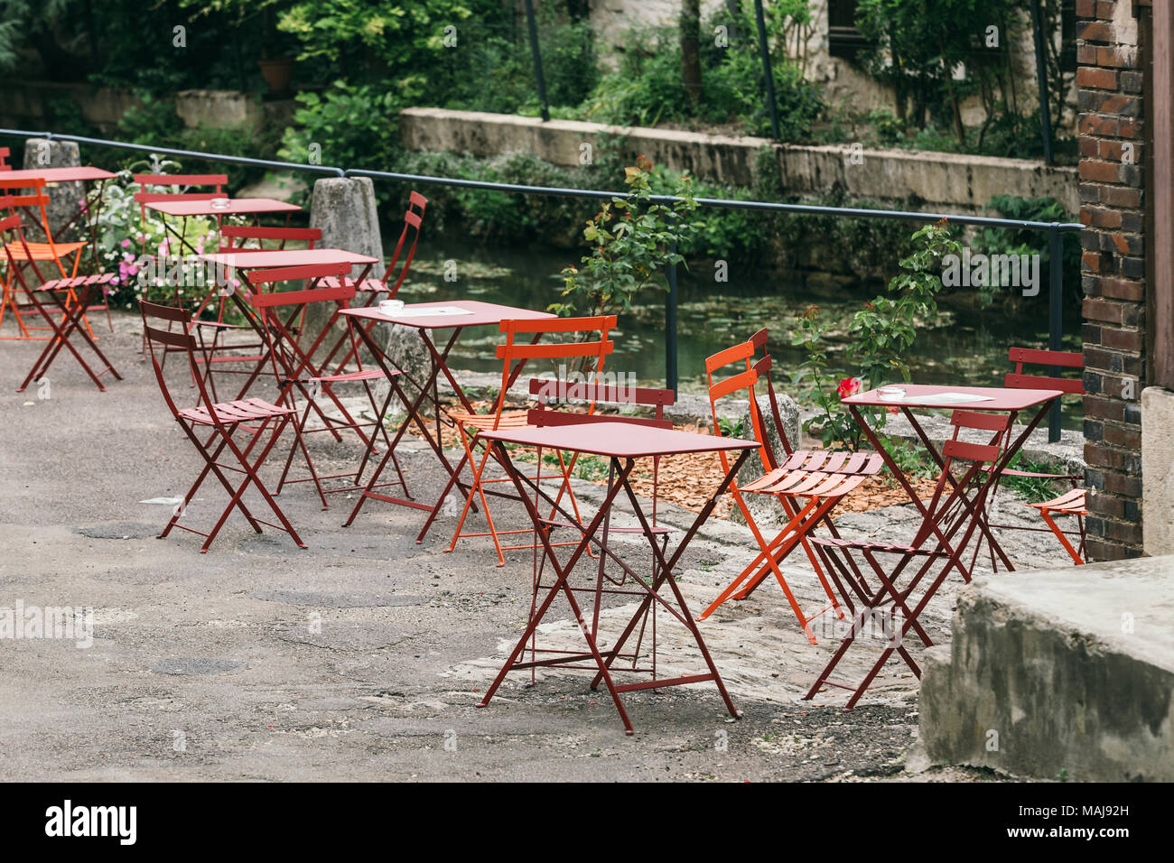 Empty red tables of street cafes in Europe Stock Photo - Alamy