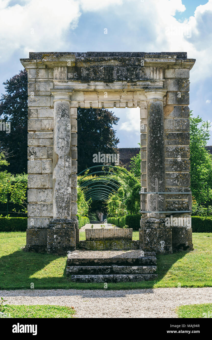 Ancient columns in the park, an ancient stone arch covered with moss ...
