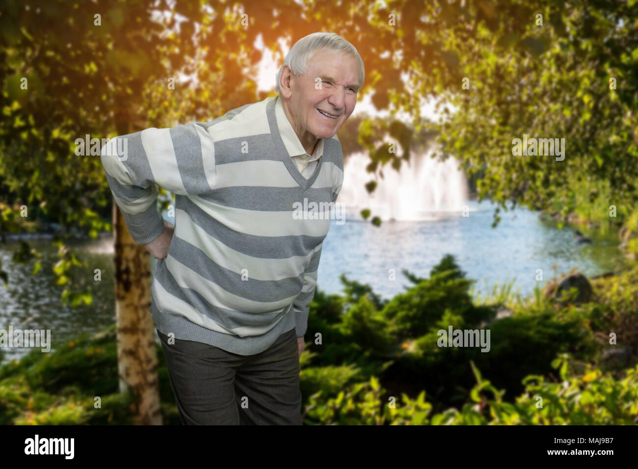 Old man with backache outdoor. Senior grandfather suffering from back ...