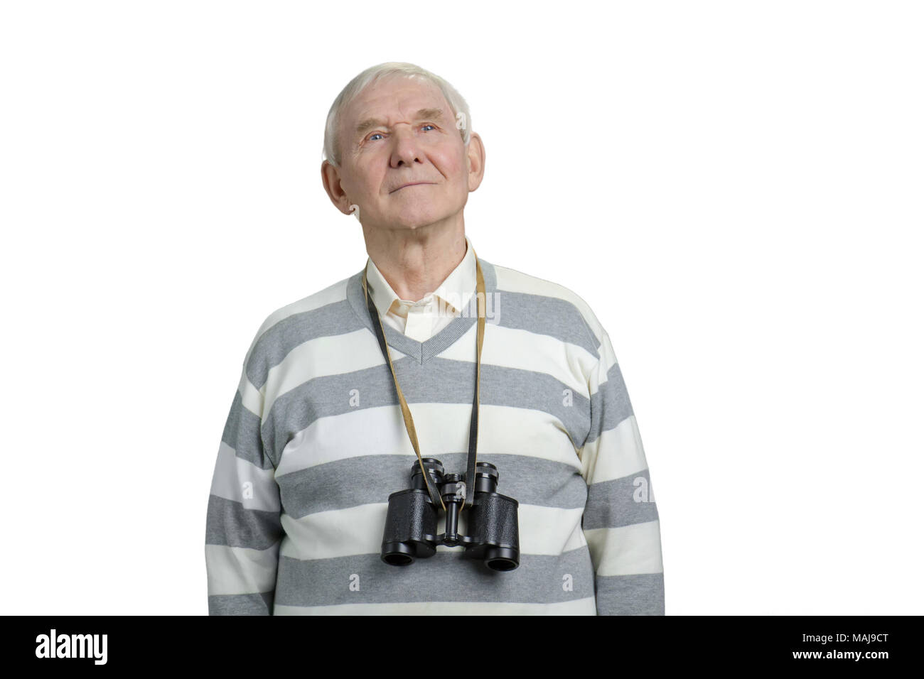 Senior man with binoculars looks up. Old tourist observing location ...