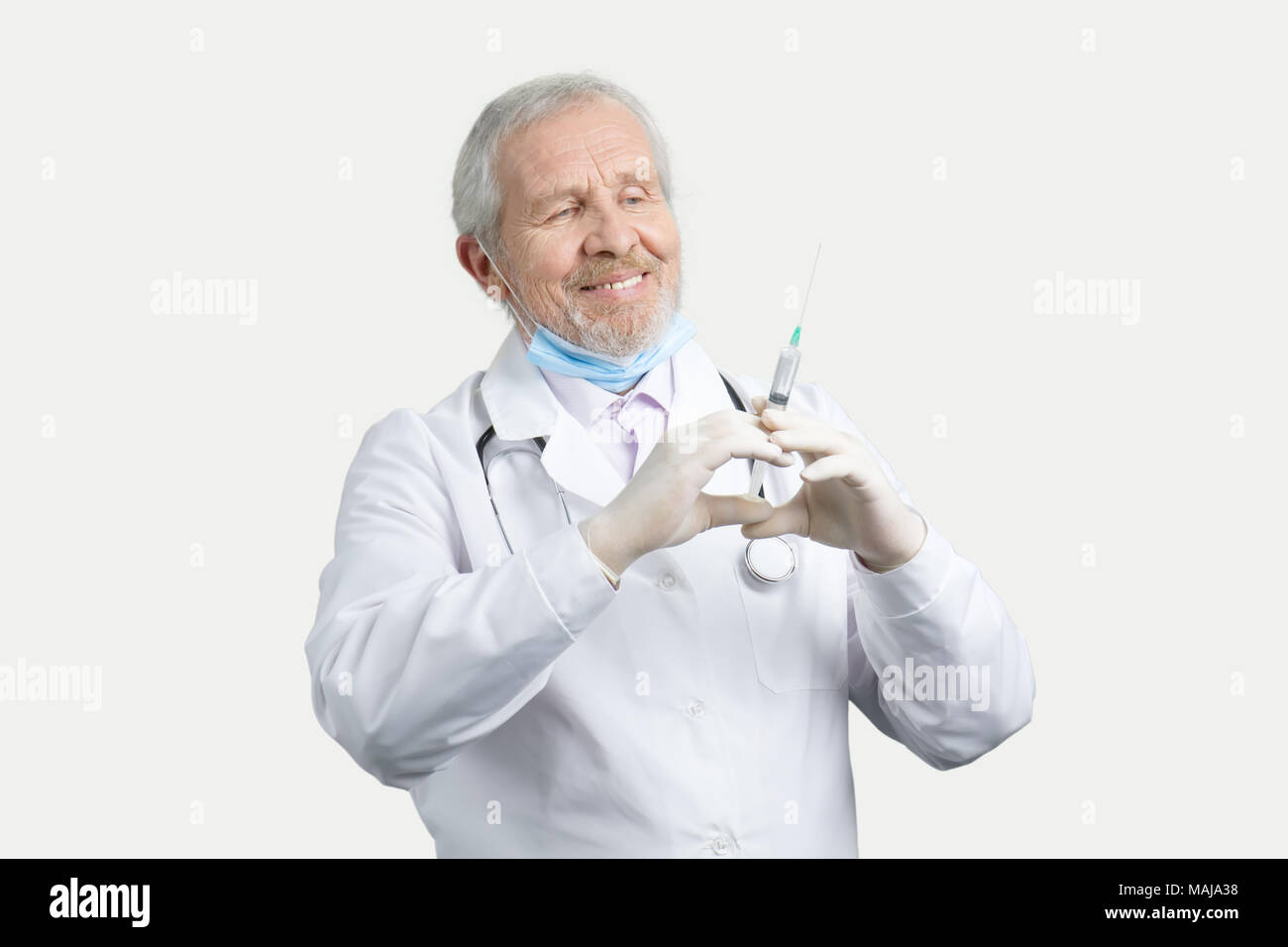 Old doctor holding a syringe for preparing injection inoculation. White ...