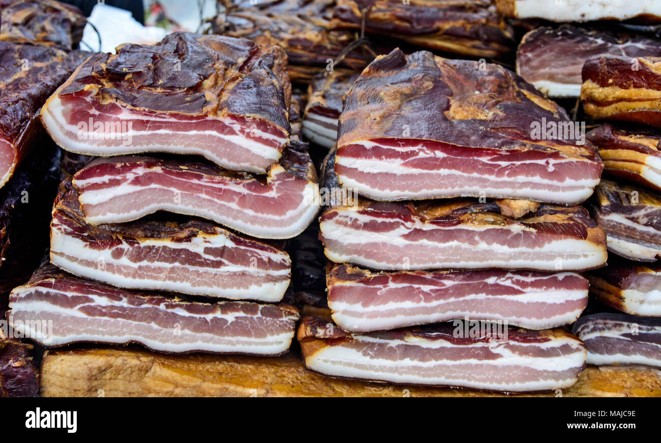 Homemade bacon on the table exposed for sale Stock Photo - Alamy