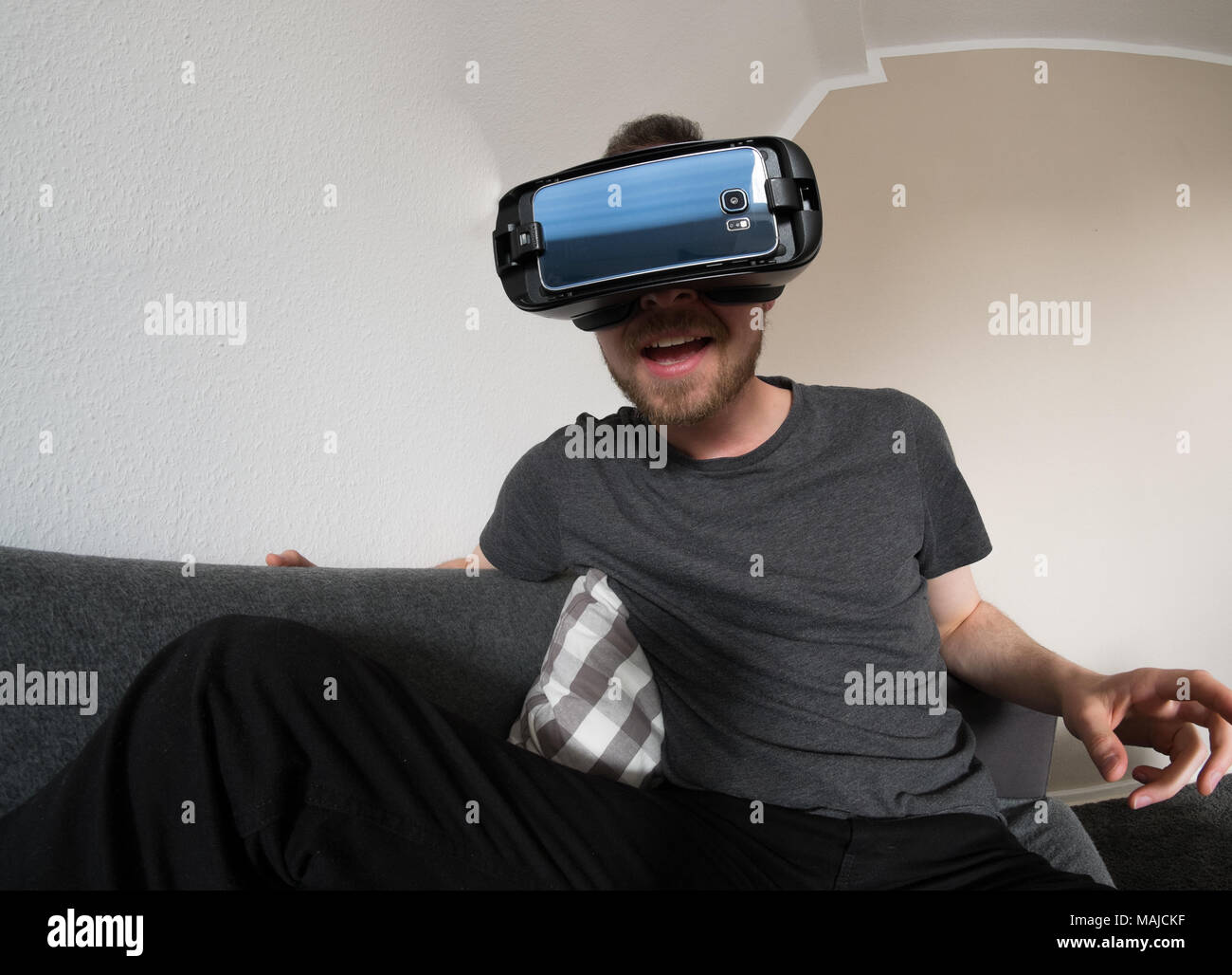 Male on a sofa enjoying a virtual reality experience Stock Photo - Alamy