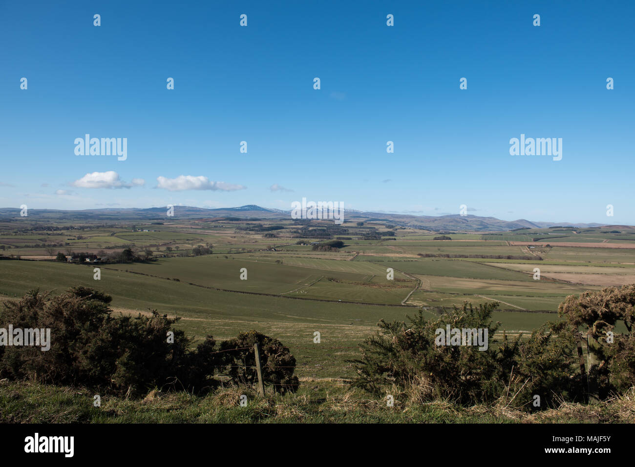 Expansive rural landscape with patchwork fields and distant snow-capped ...