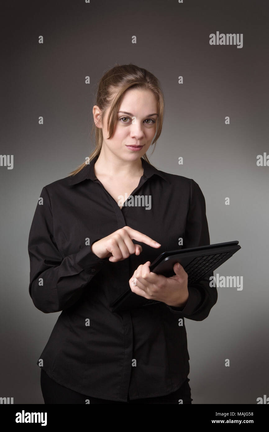 young business woman using a computer shot in the studio on a grey ...