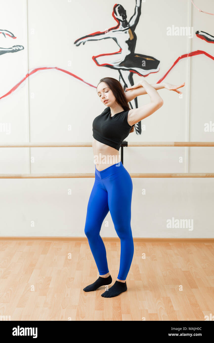Cute young girl wearing black top and blue pants doing physical ...