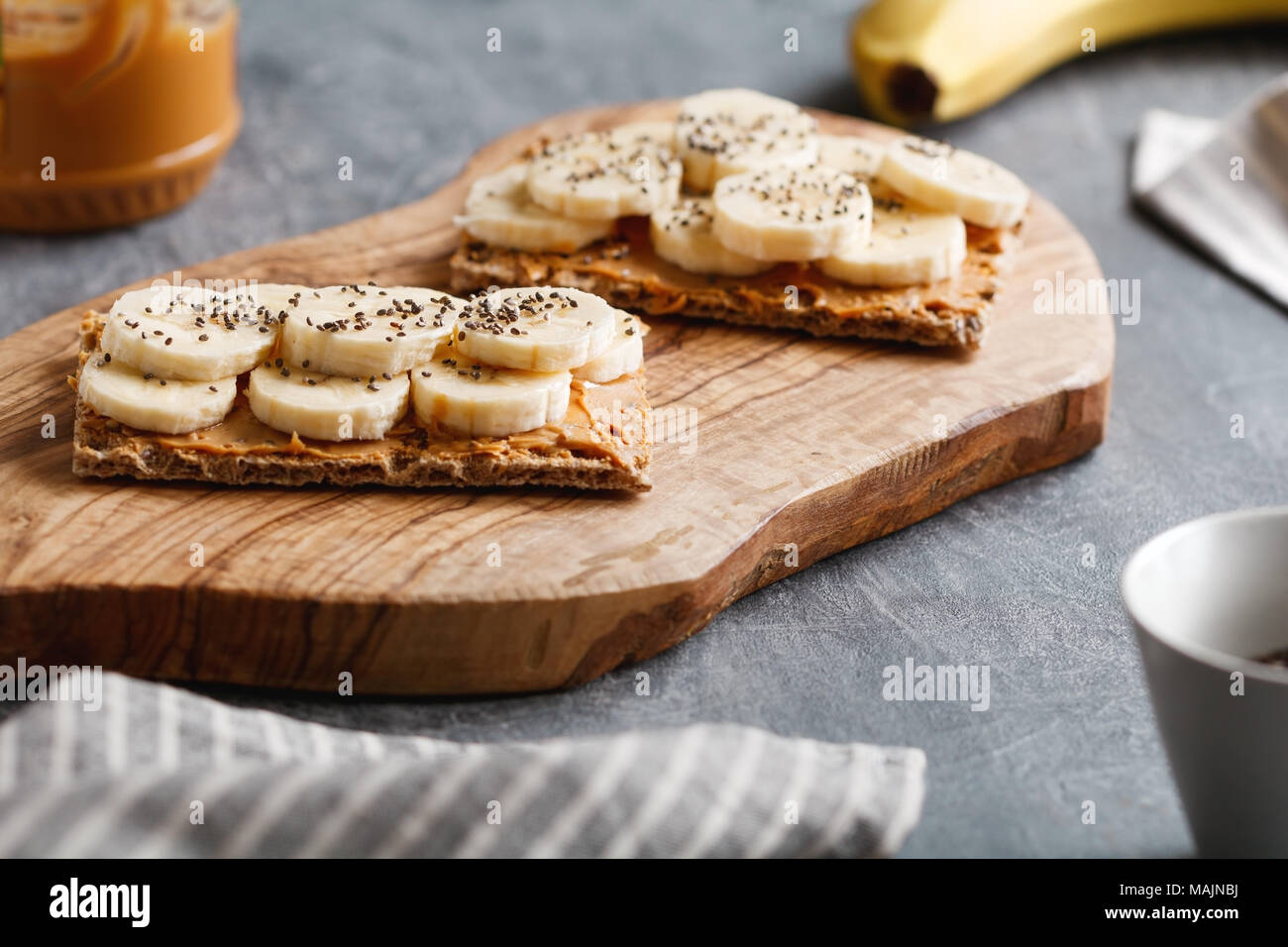 Two toasts from multi grain breads with peanut paste, banana slices and ...