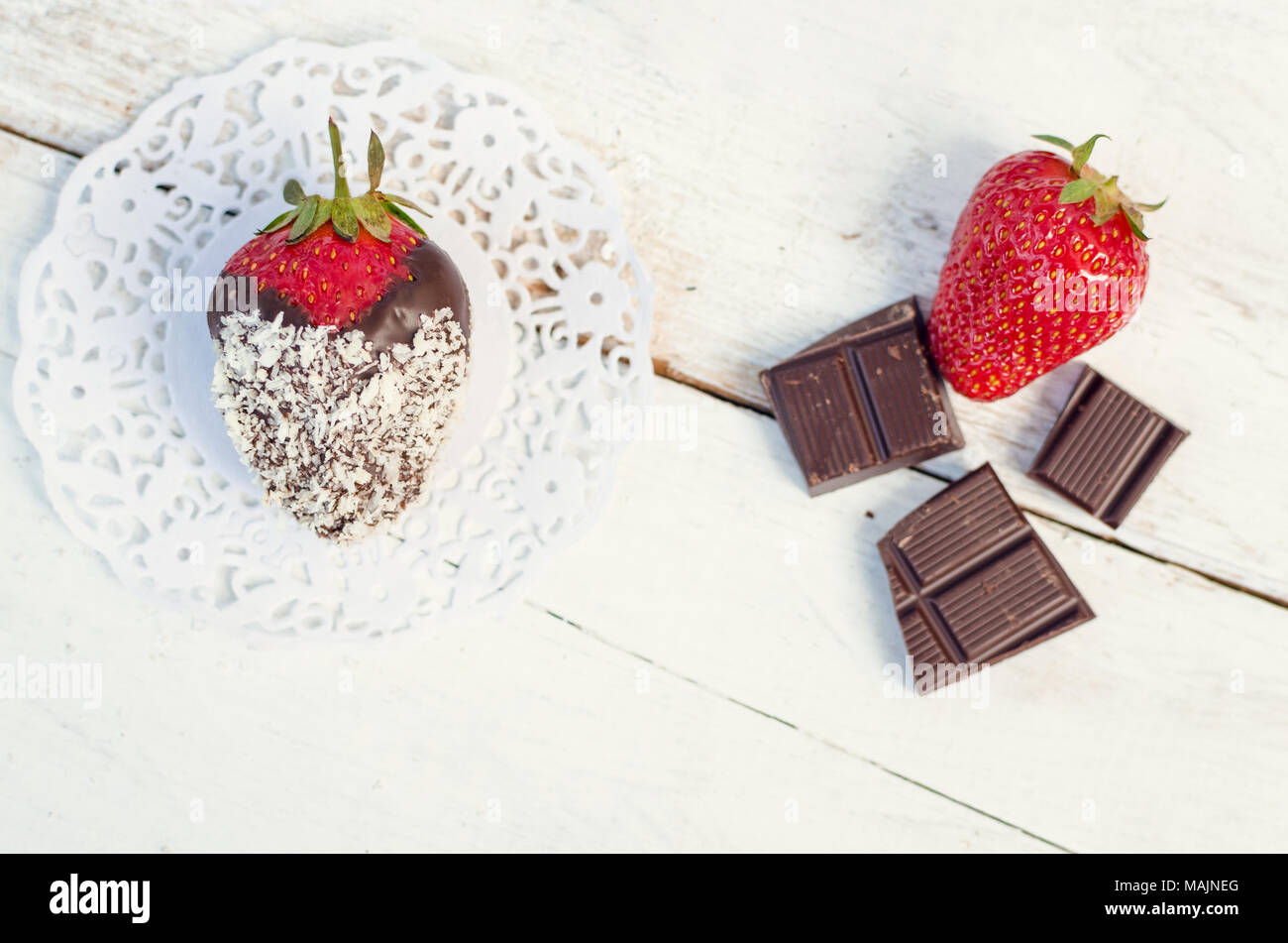 Strawberrie covered with a dark chocolate with coconut on the white ...