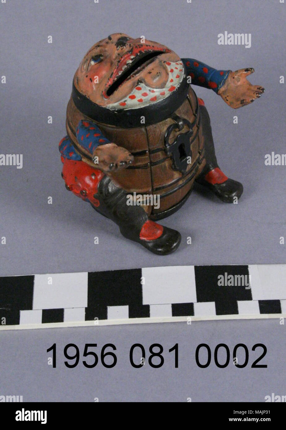 Cast iron coin bank shaped as a man in a barrel. Coins are deposited in ...