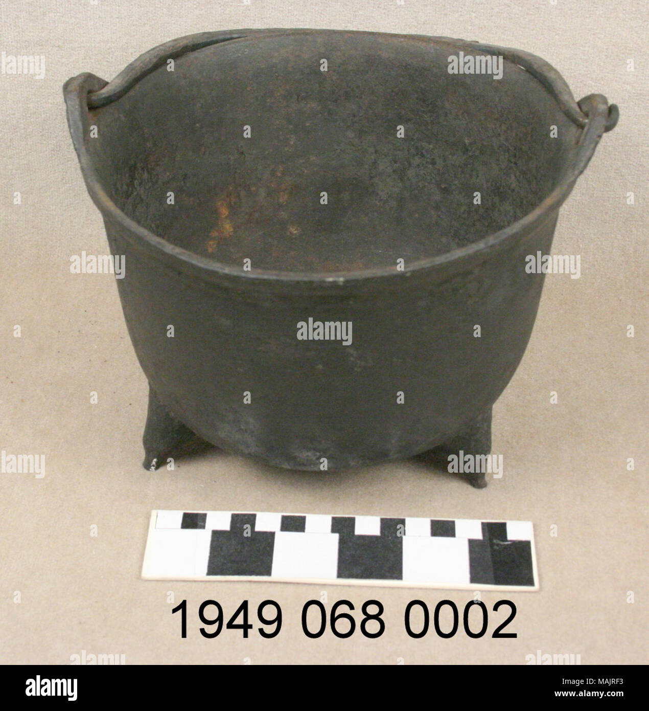 Small, black, cast iron cooking kettle with three legs and bail handle ...