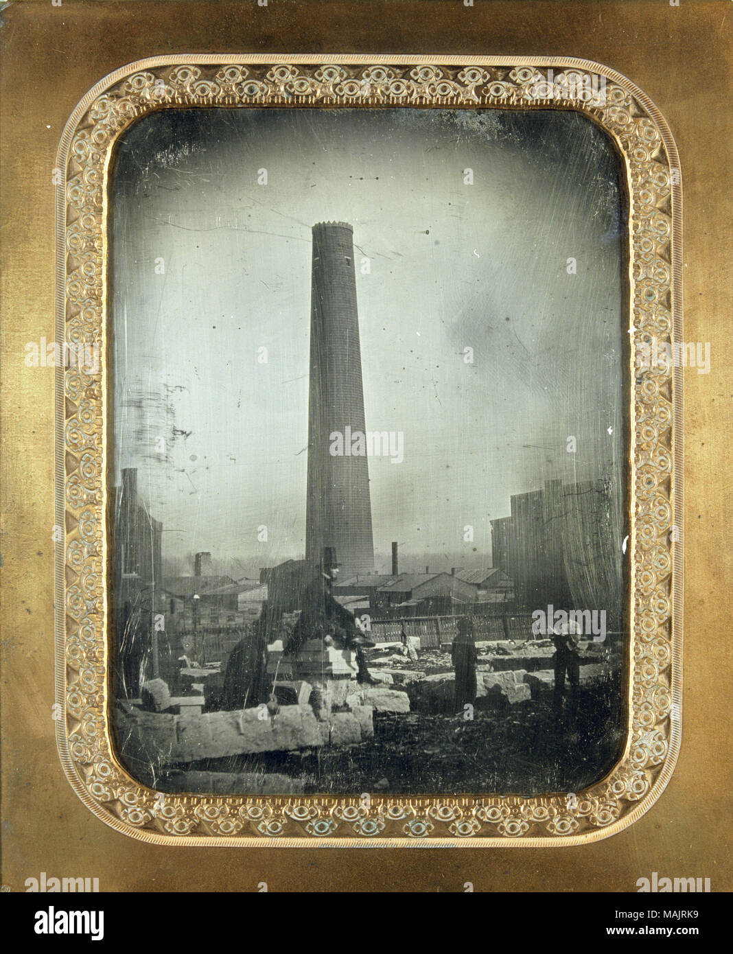 Two men in top hats sit on top of construction materials in front of ...