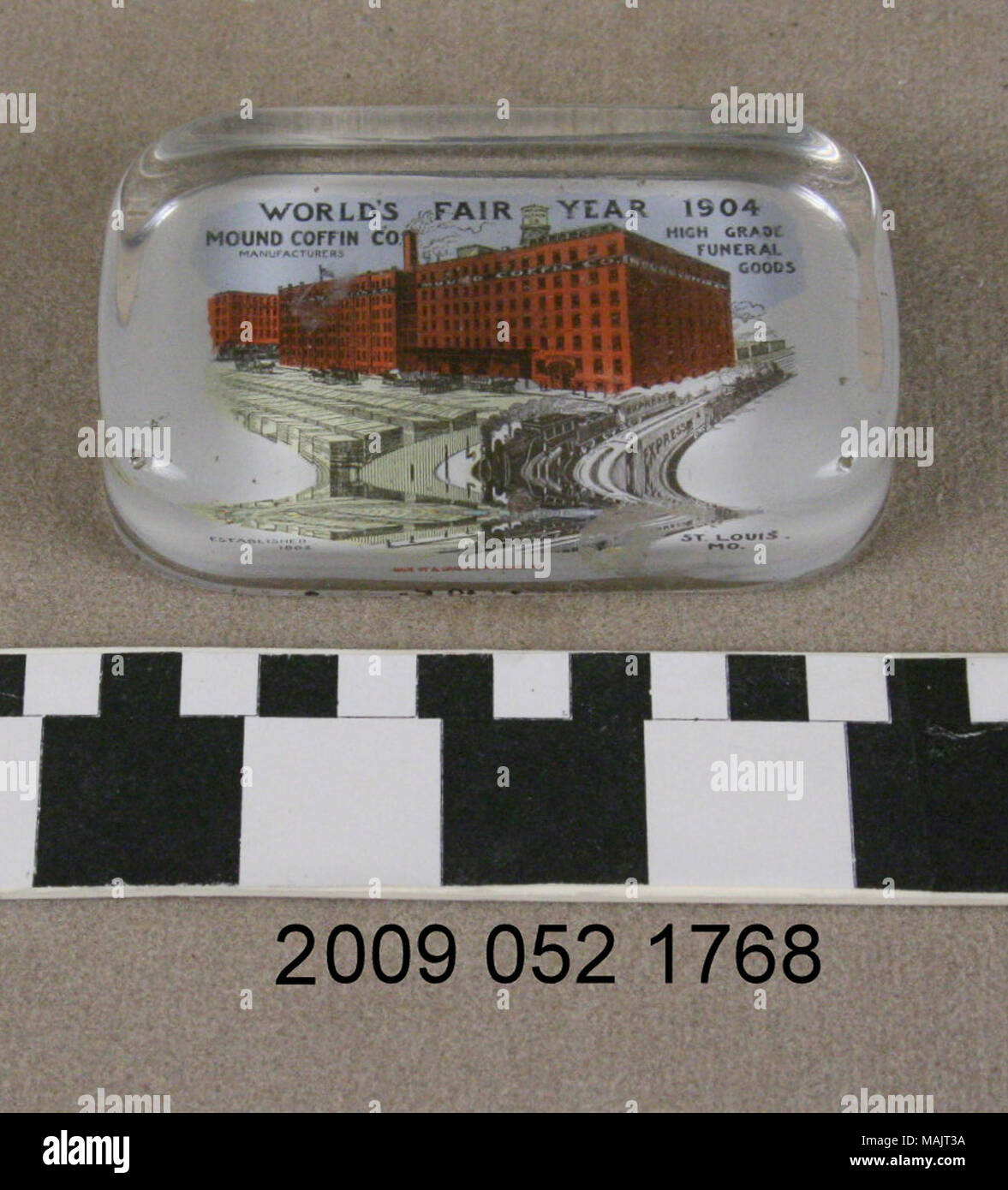 Rectangular glass paperweight shows an advertisement for the Mound ...