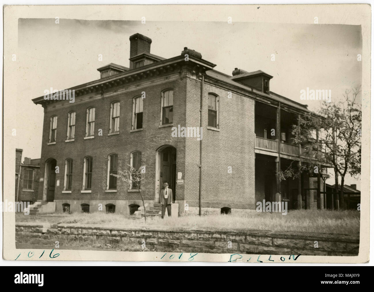 Horizontal, black and white photograph of a three story brick multi ...