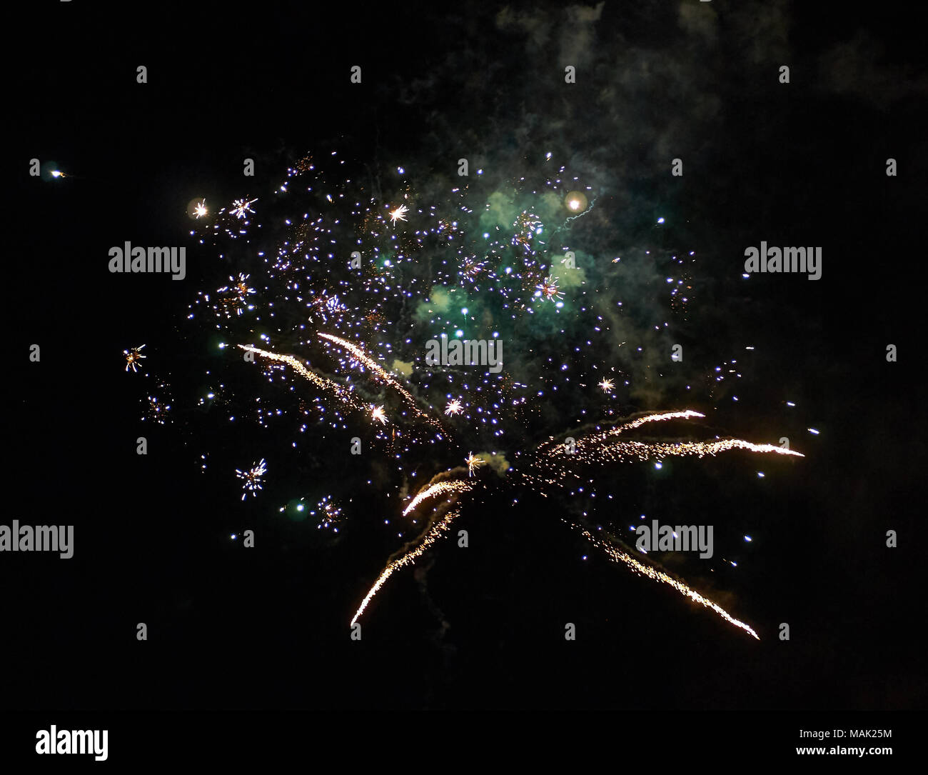 Colorful bright green fireworks and smoke in the night sky close-up ...