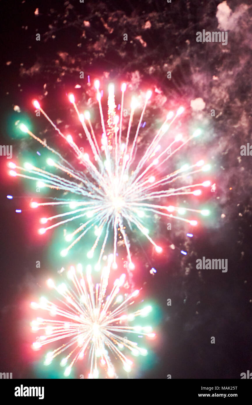 Colorful bright red and green fireworks and smoke in the night sky ...