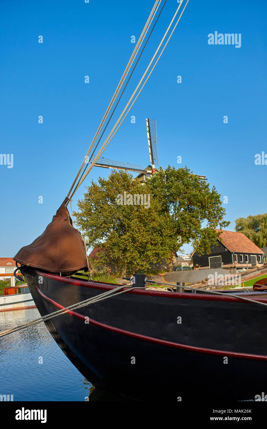 Traditional Dutch Sailing Tjalk windmill, trees and buildings in the ...