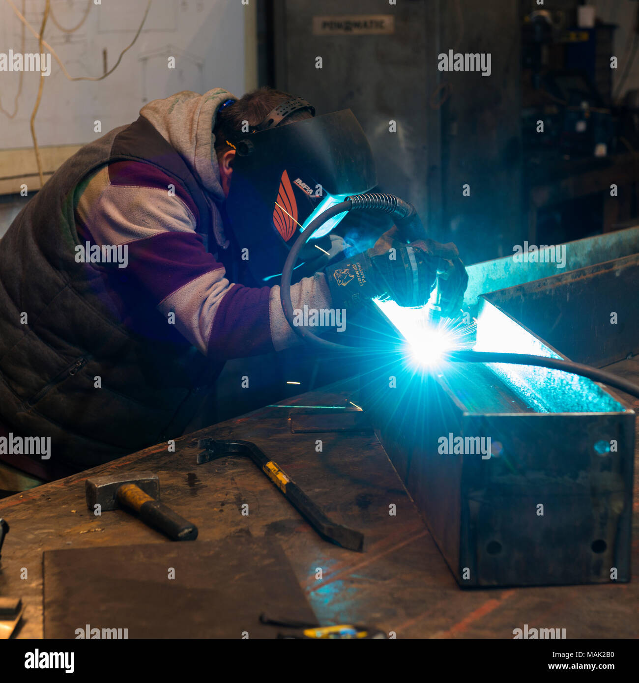 Welder arc welding steel frame Stock Photo - Alamy