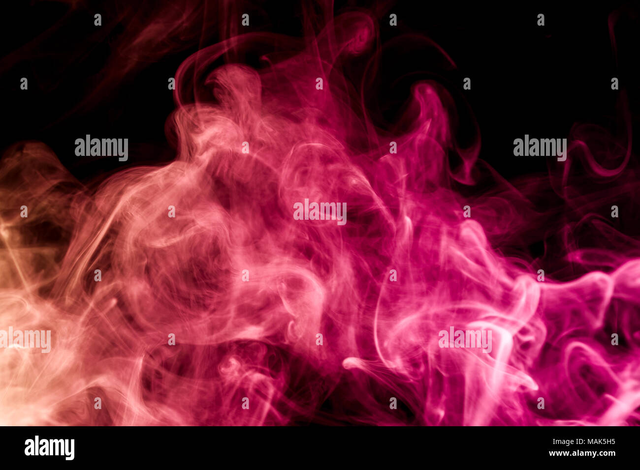Dense multicolored smoke of red and pink colors on a black isolated ...