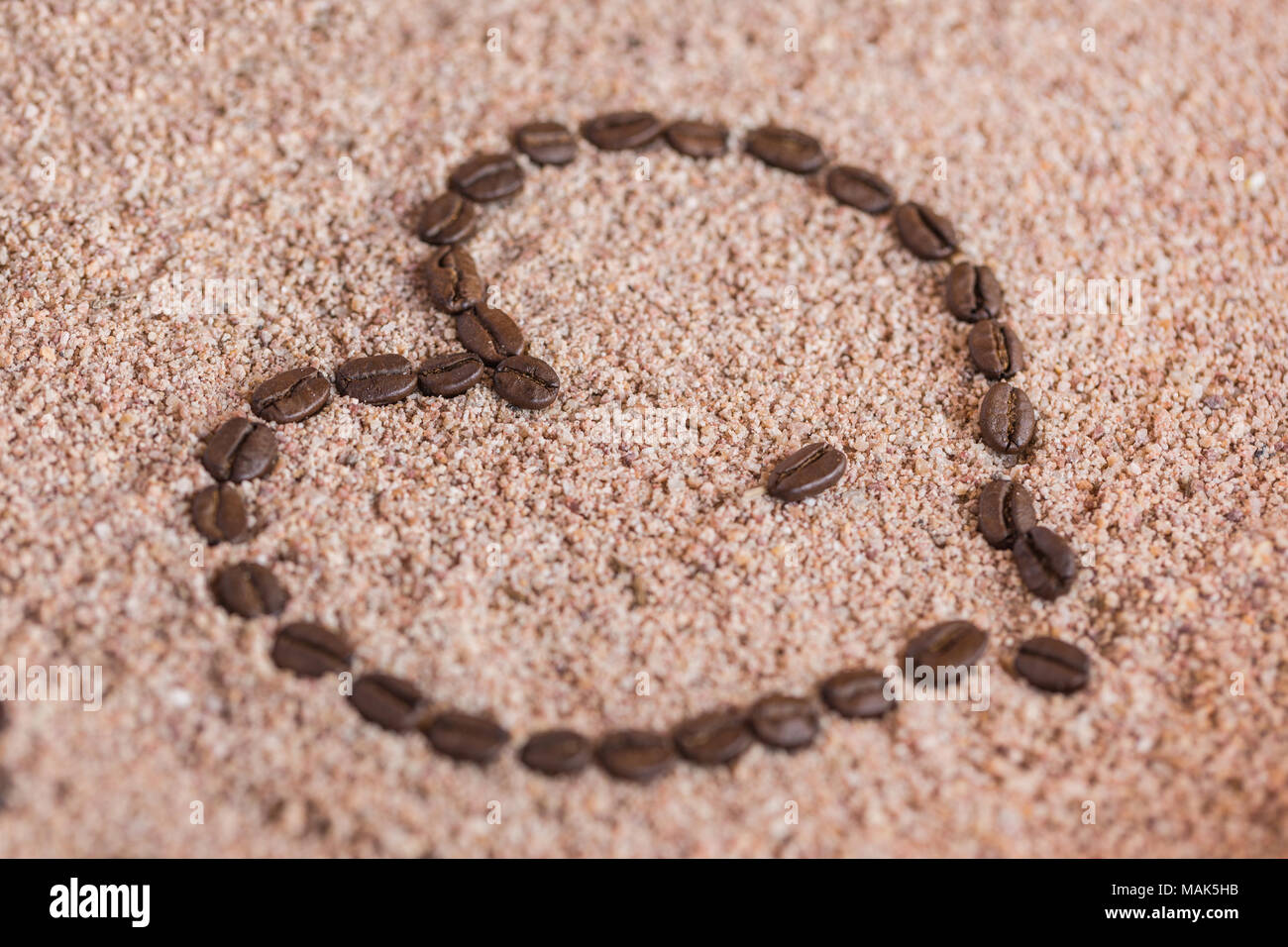 Heart shape made from coffee beans on on sand Stock Photo - Alamy