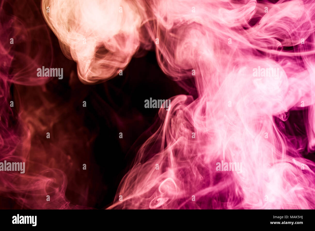Thick colorful smoke of red, pink on a black isolated background ...