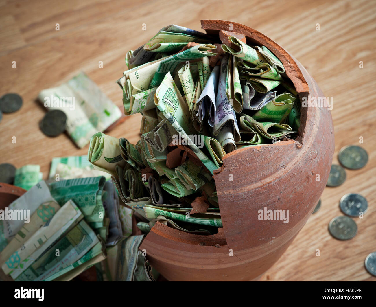 Broken money box, with Saudi Riyal banknotes and coins Stock Photo - Alamy
