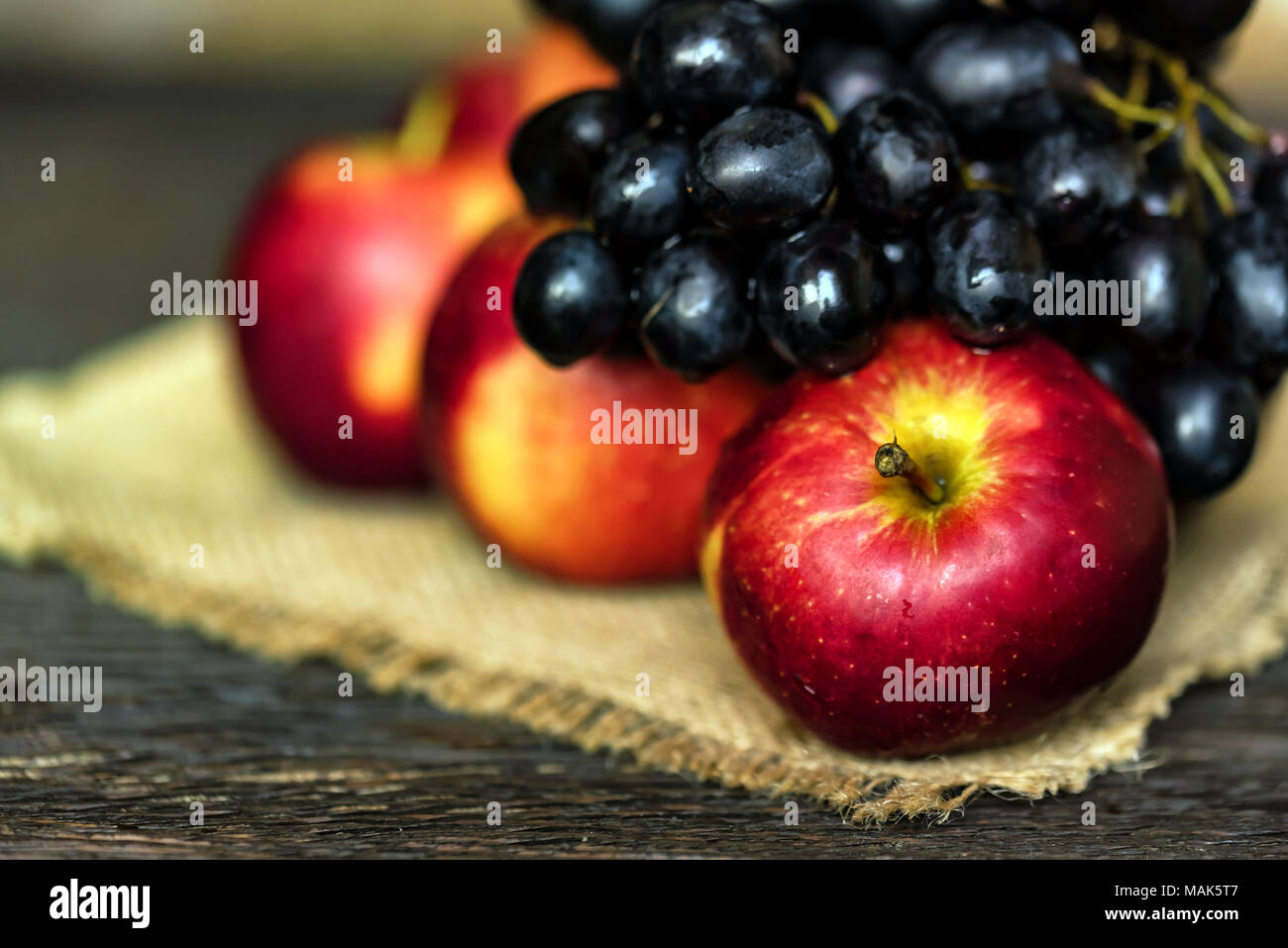 Fresh ripe red apples and grapes on burlap napkin Stock Photo - Alamy