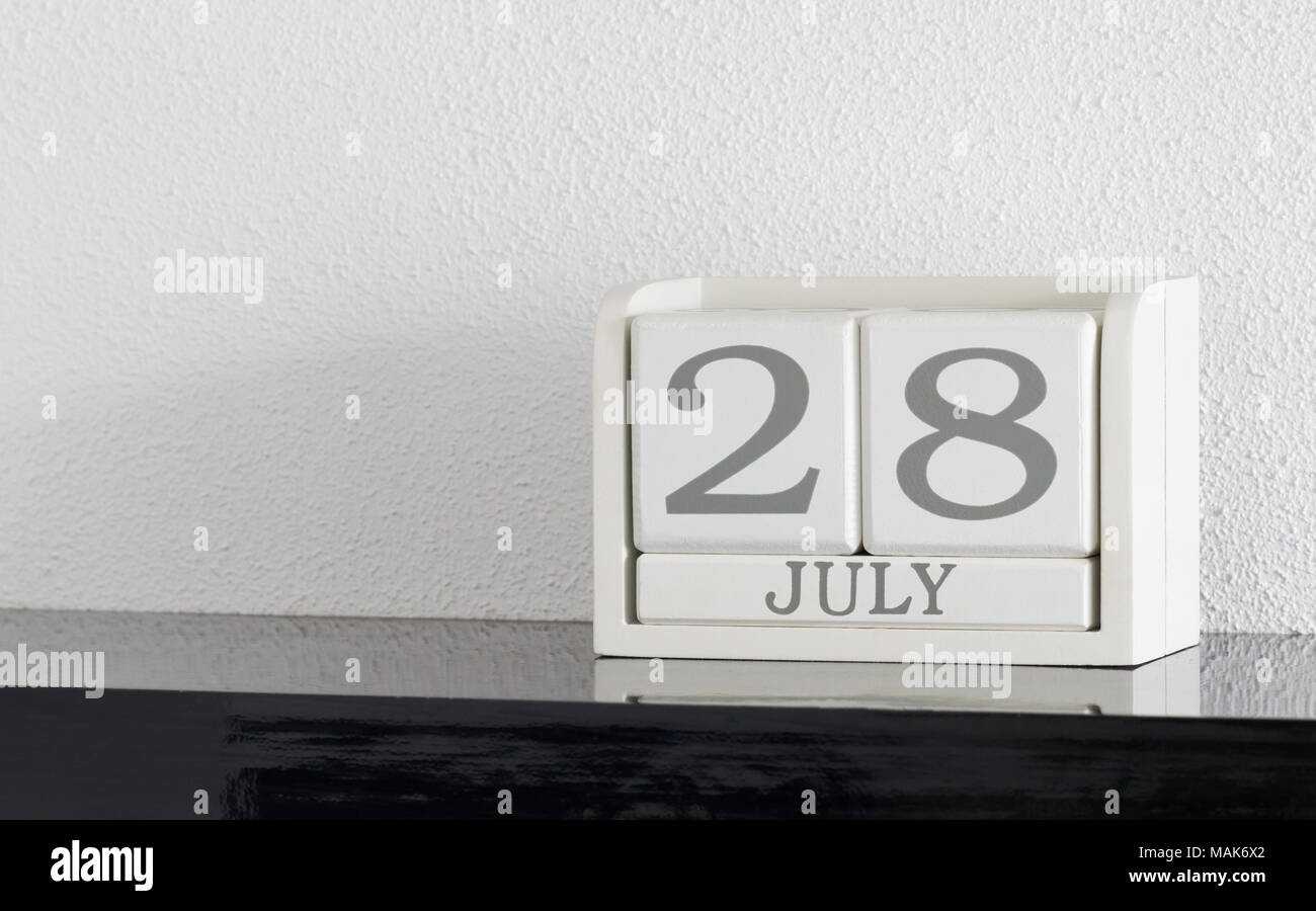 White block calendar present date 28 and month July on white wall ...