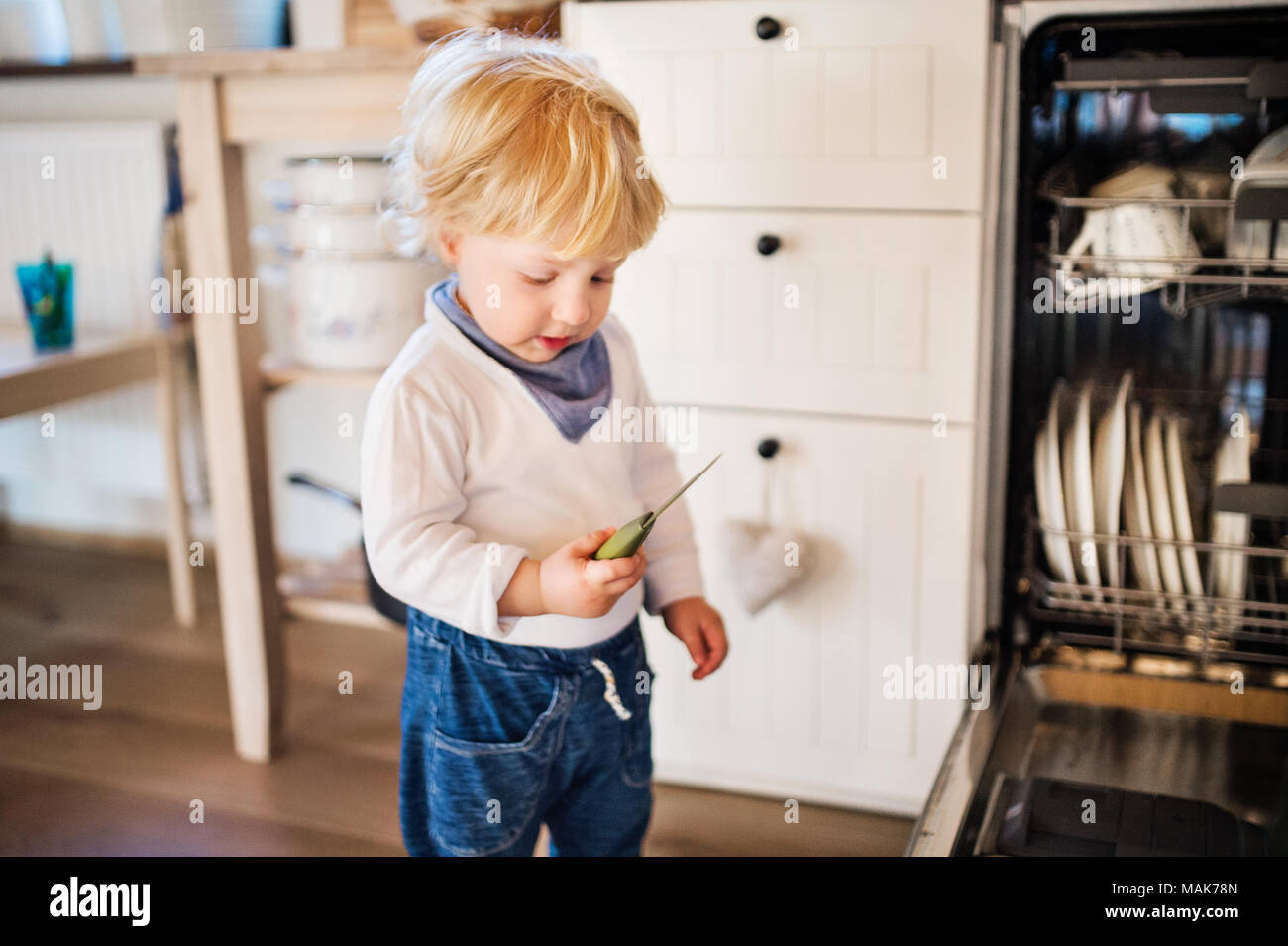 Toddler boy in dangerous situation at home. Child safety concept Stock ...