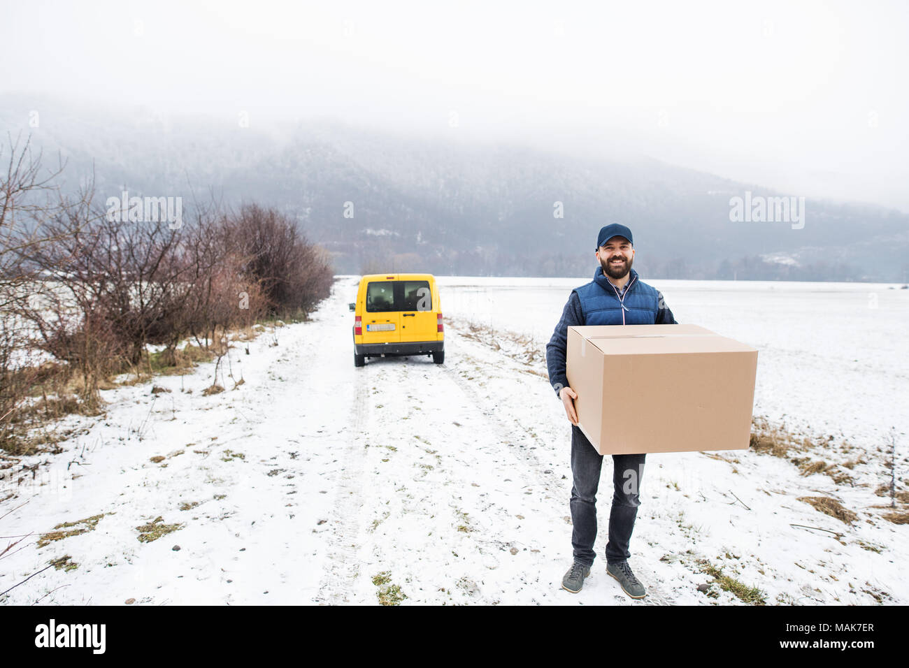 Delivery man delivering parcel box to recipient Stock Photo - Alamy