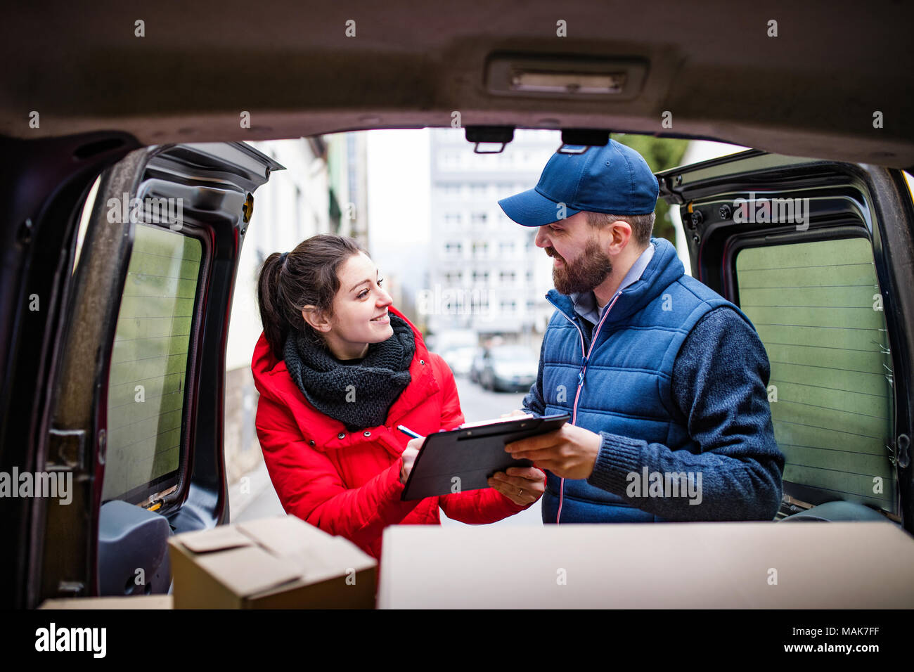 Woman receiving parcel from delivery man Stock Photo - Alamy