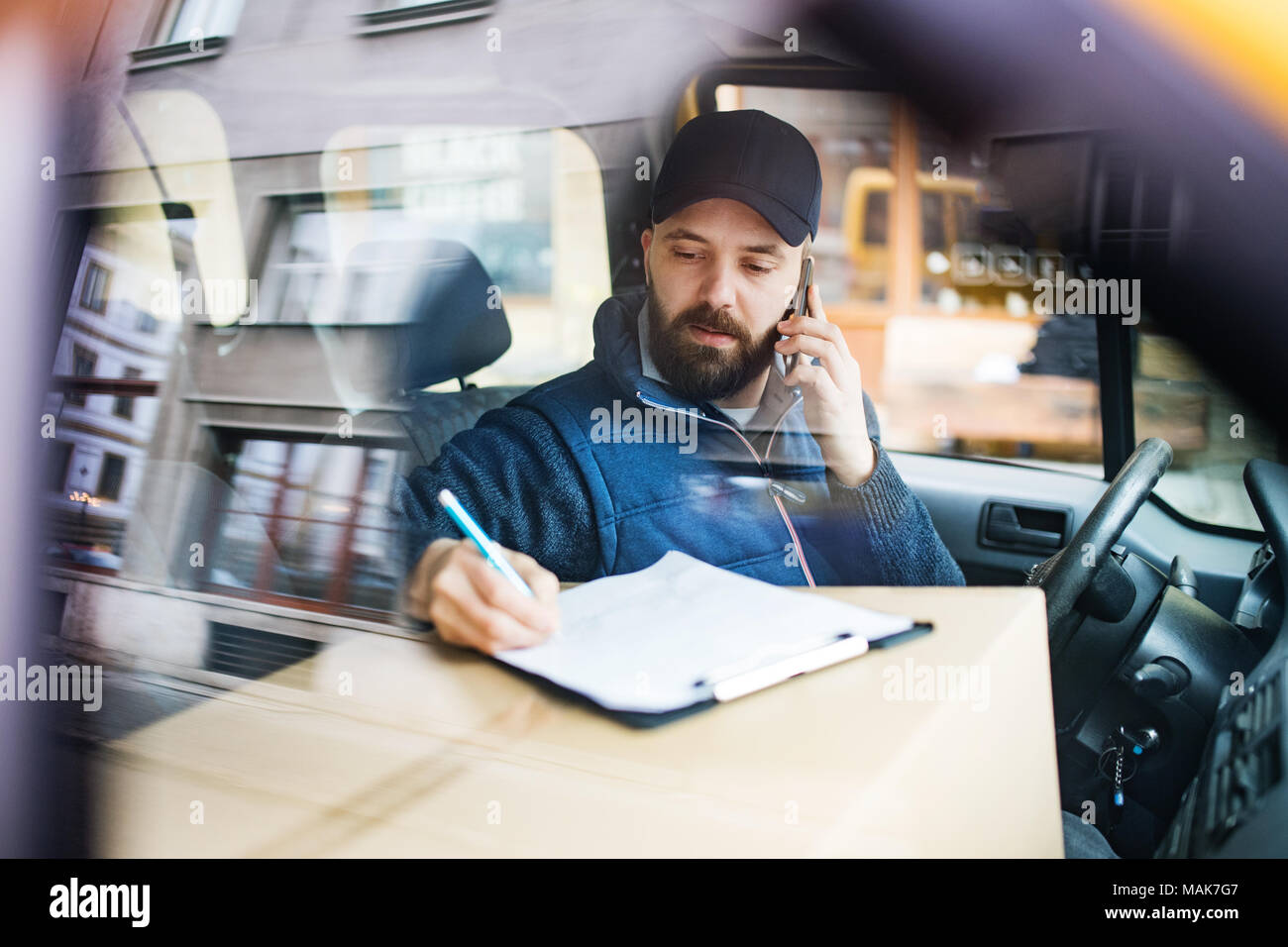 Delivery man with a parcel box in the car Stock Photo - Alamy