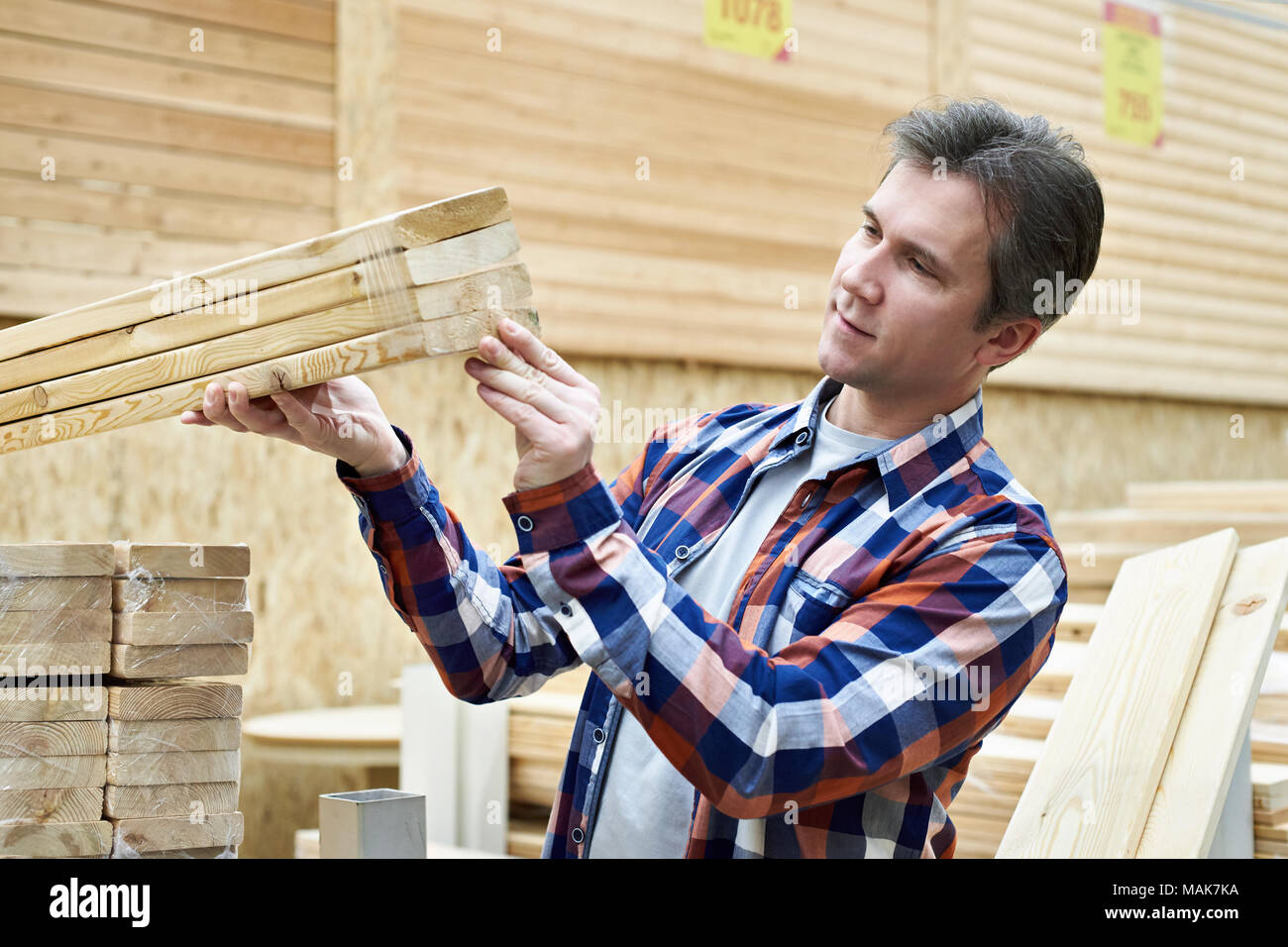 Man chooses and buys wooden boards in a construction supermarket Stock ...