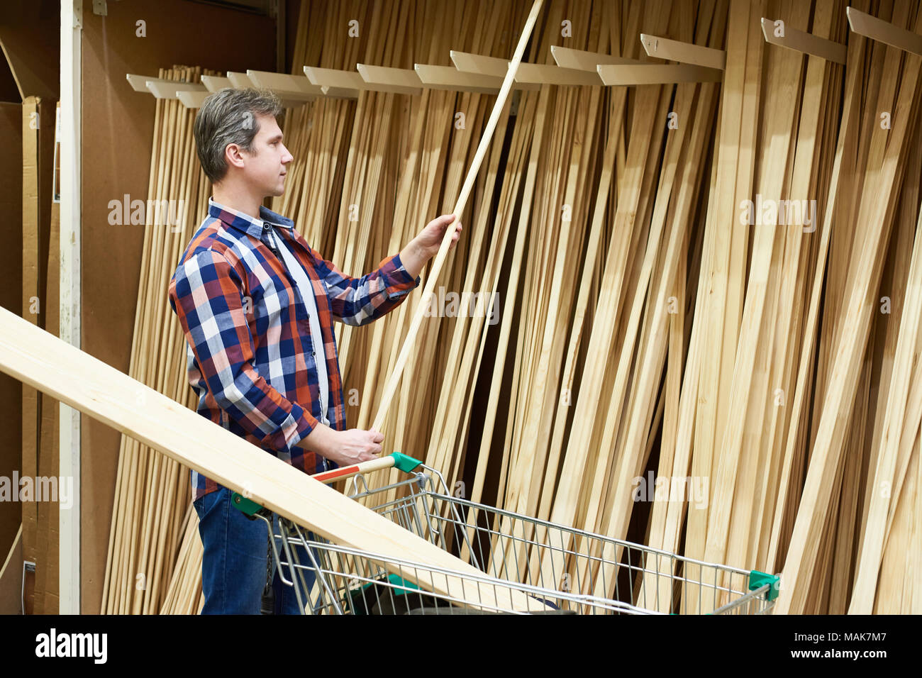 Man chooses and buys wooden boards in a construction supermarket Stock ...