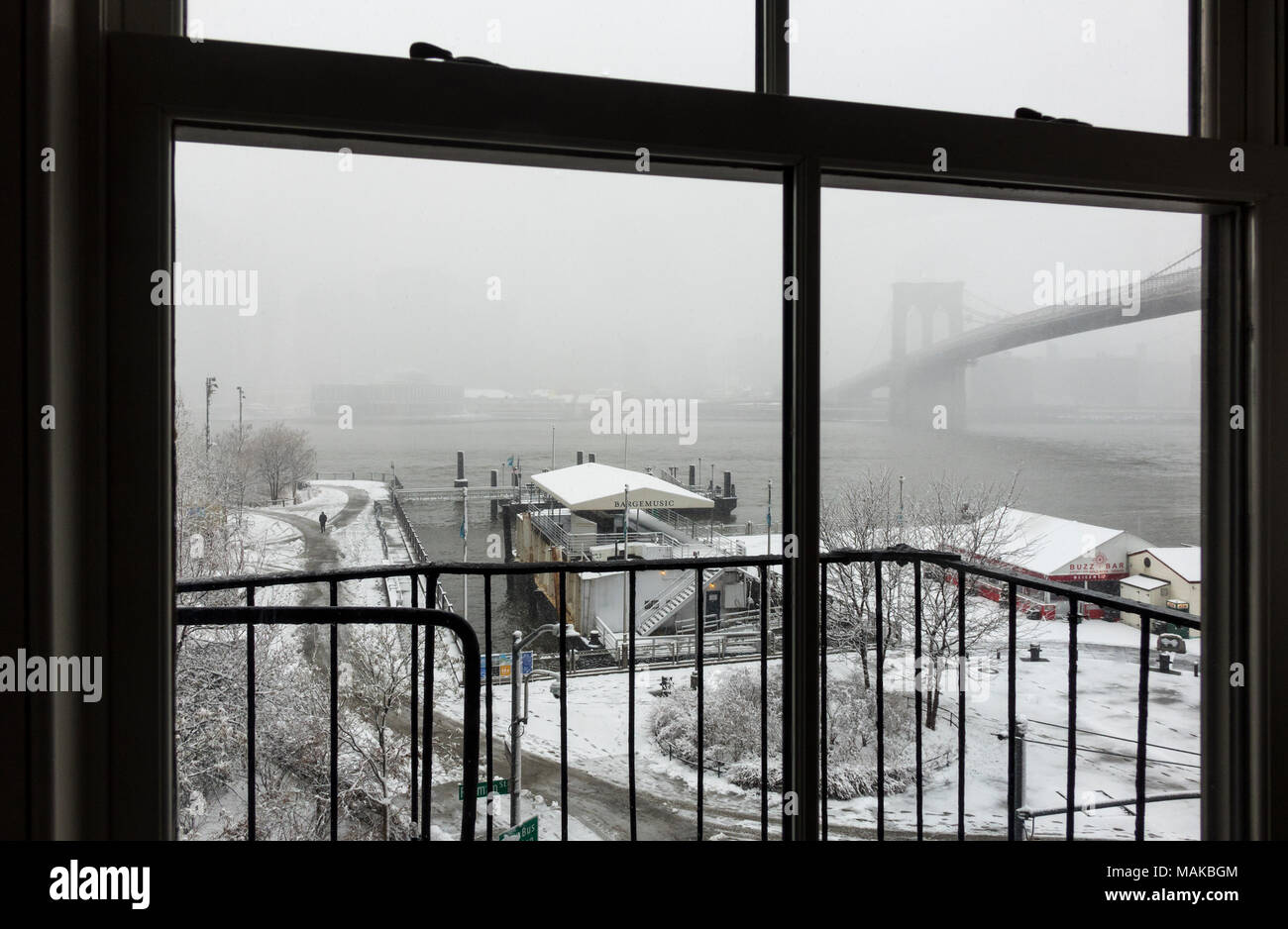 View of a snow storm out a window of a building with a fire escape in ...