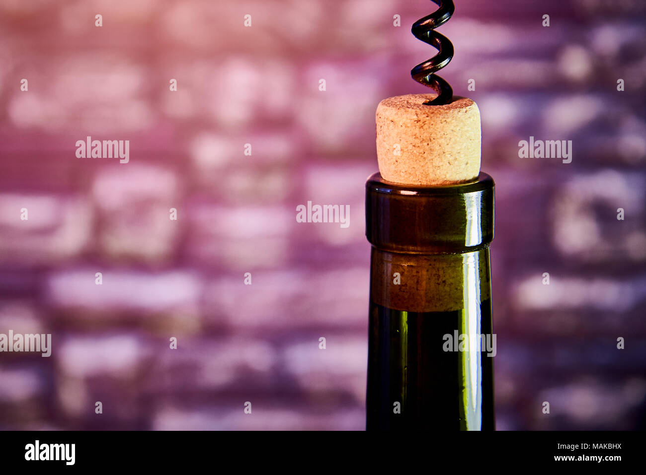 Neck of a bottle of wine with a cork and a corkscrew on the background ...