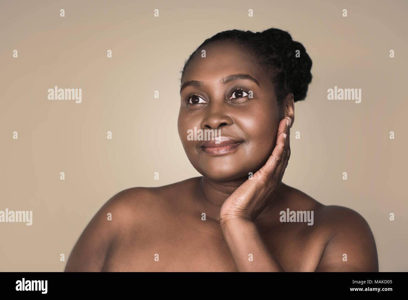 Young African woman smiling and touching her cheek Stock Photo - Alamy