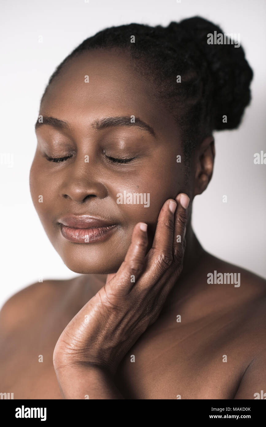 African woman with her eyes closed touching her cheek Stock Photo - Alamy
