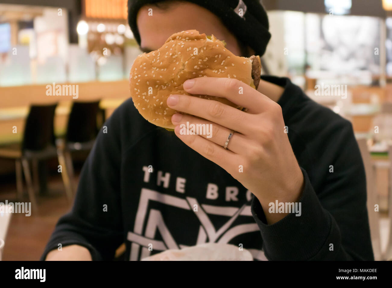 Young man eating burger Stock Photo - Alamy