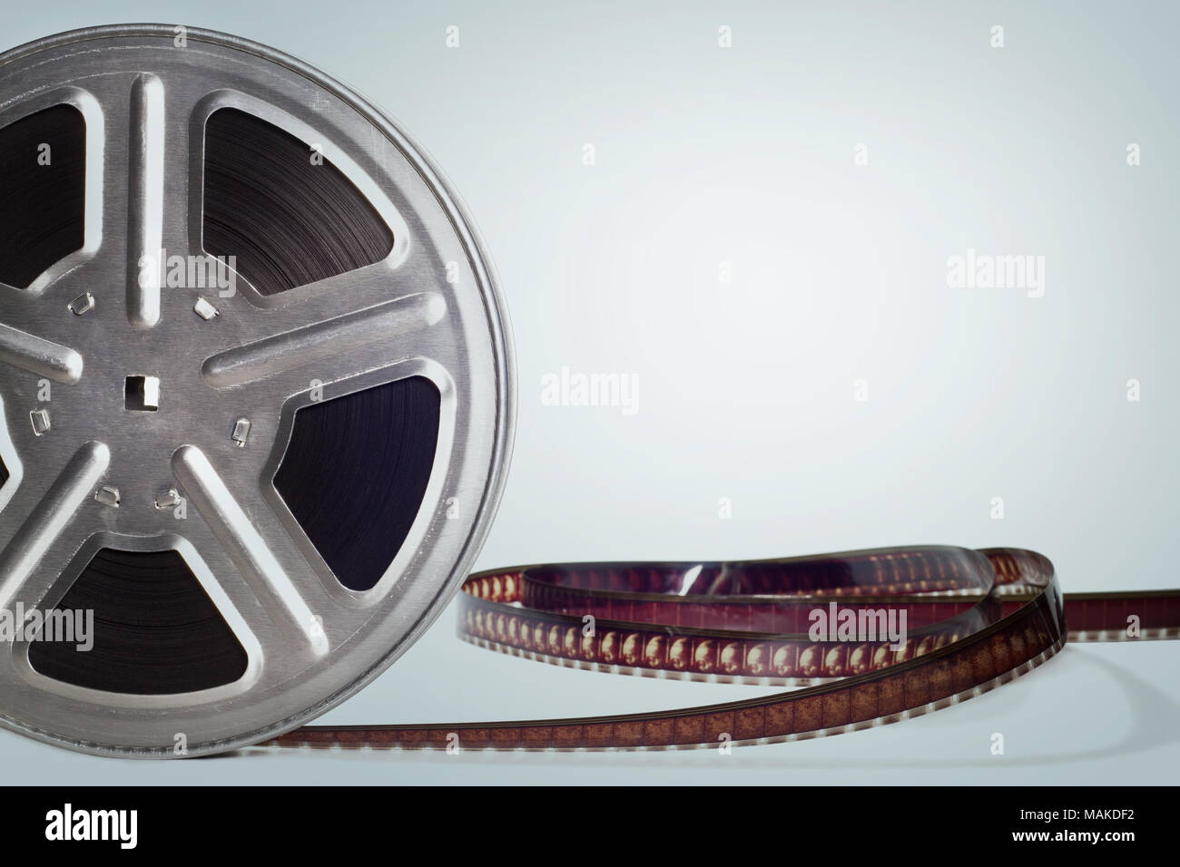 Old motion picture film reel on light blue background Stock Photo - Alamy
